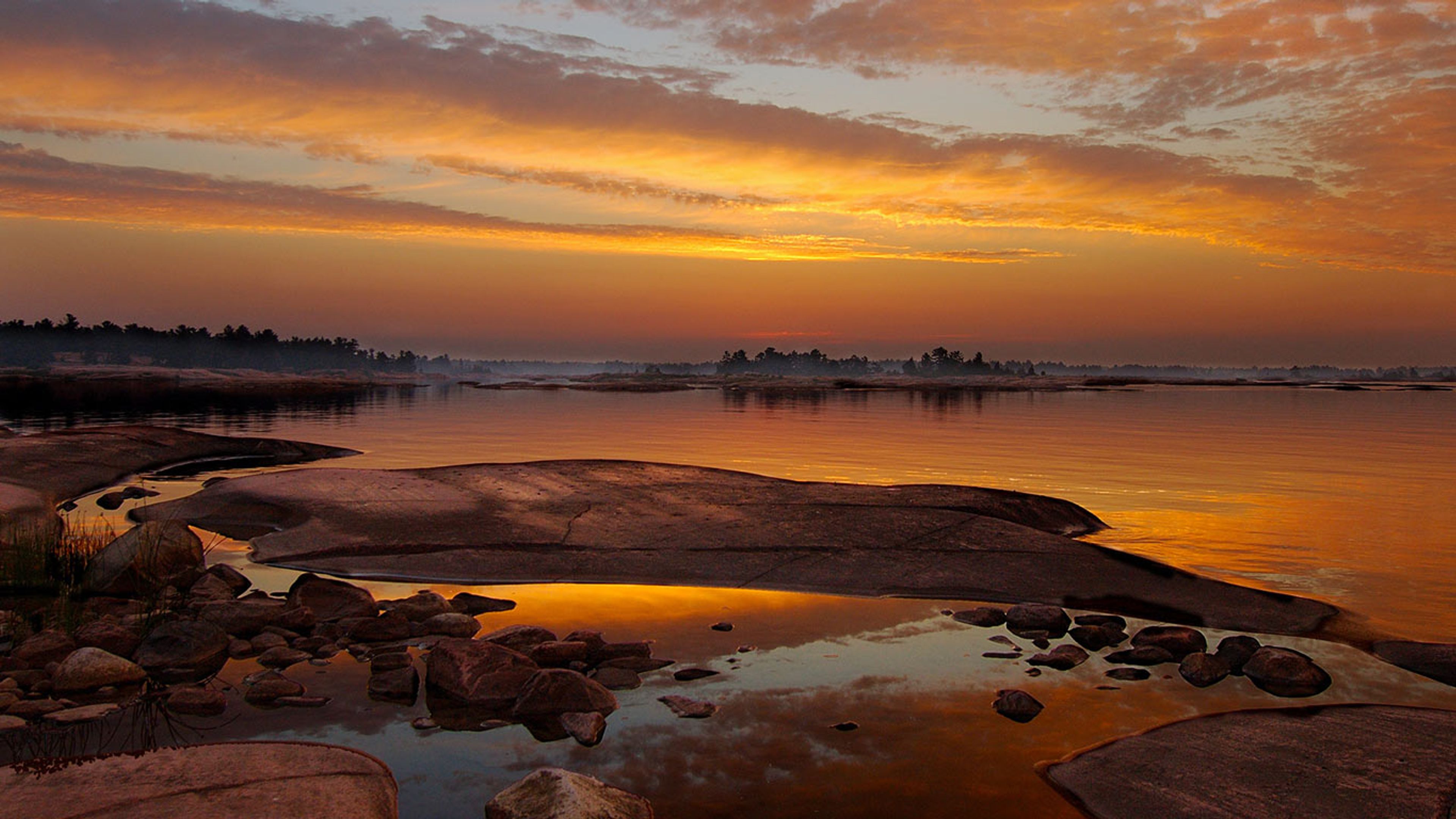 Golden sunrise over the polished granite and water of Georgian Bay ...