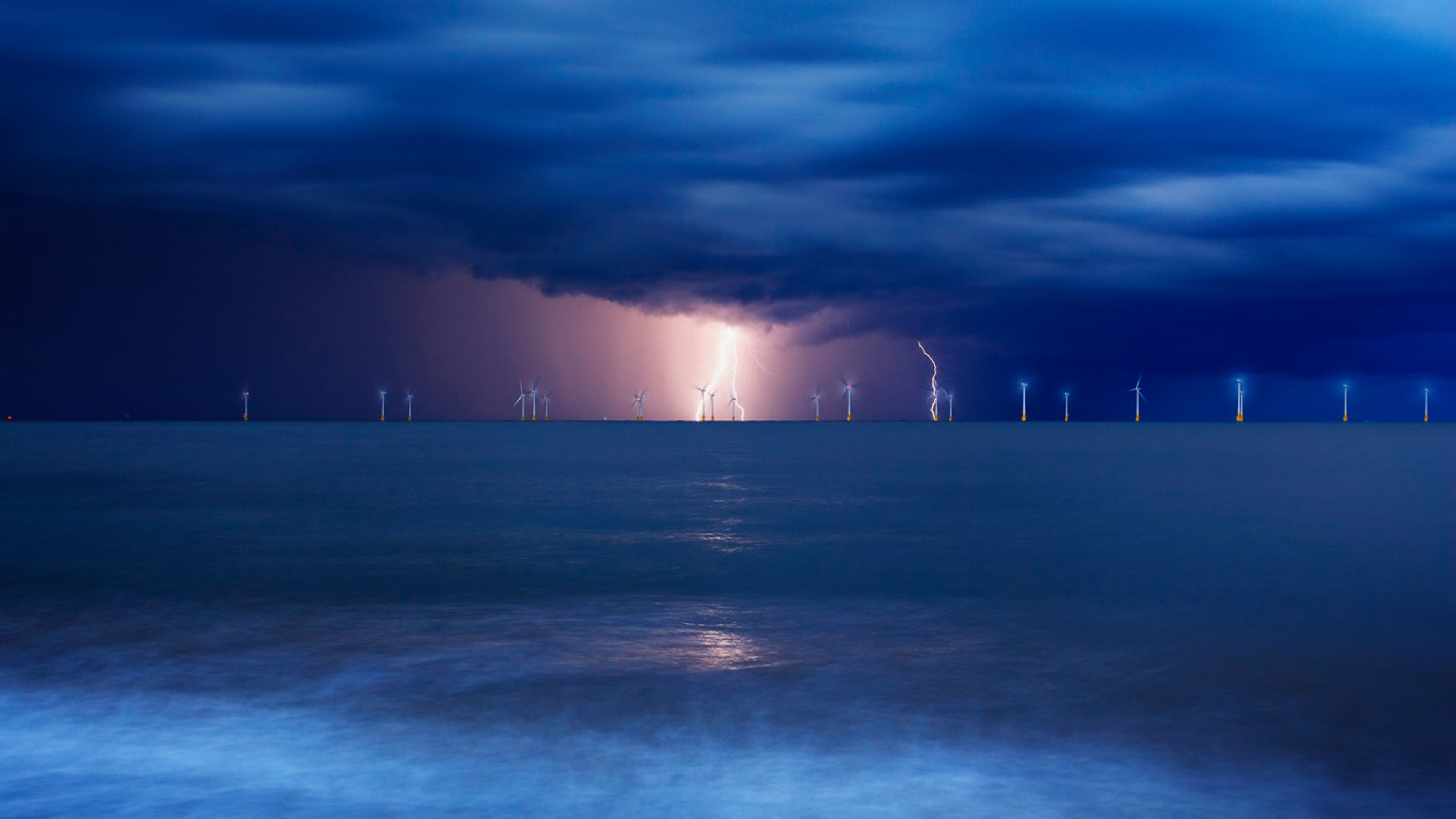 Offshore wind farm at Great Yarmouth in Norfolk in a lightning storm ...