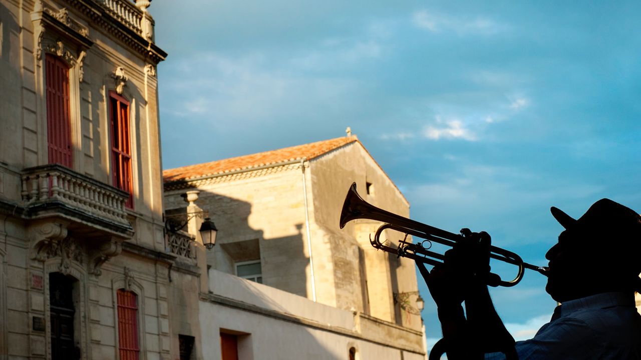 Silhouette d’un trompettiste dans une rue d’Arles, Bouches-du-Rhône ...