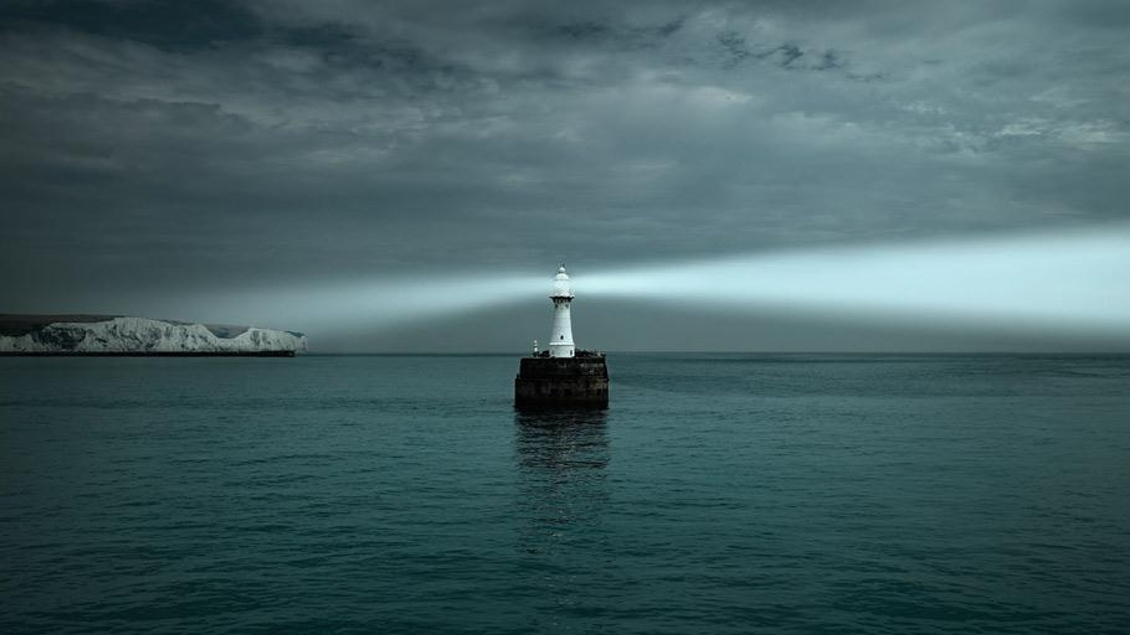 Lighthouse shining on White Cliffs of Dover and the English Channel ...