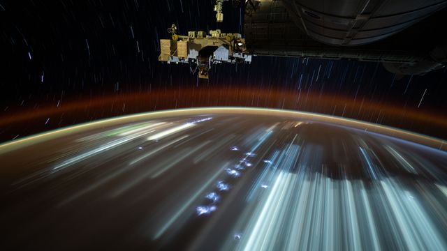 City lights streak below, taken from the International Space Station ...