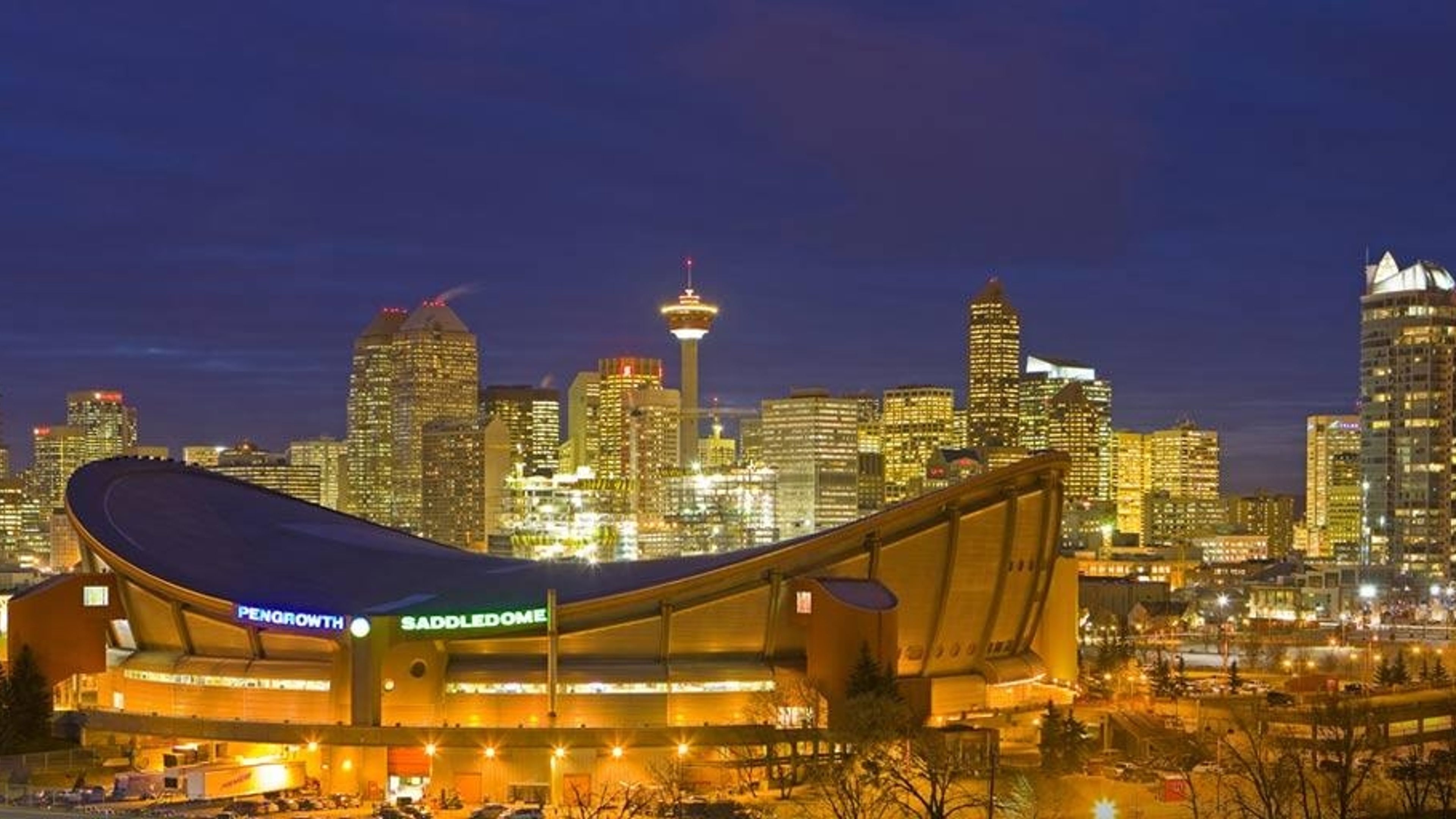 The Saddledome with Calgary Tower and the city skyline in the ...