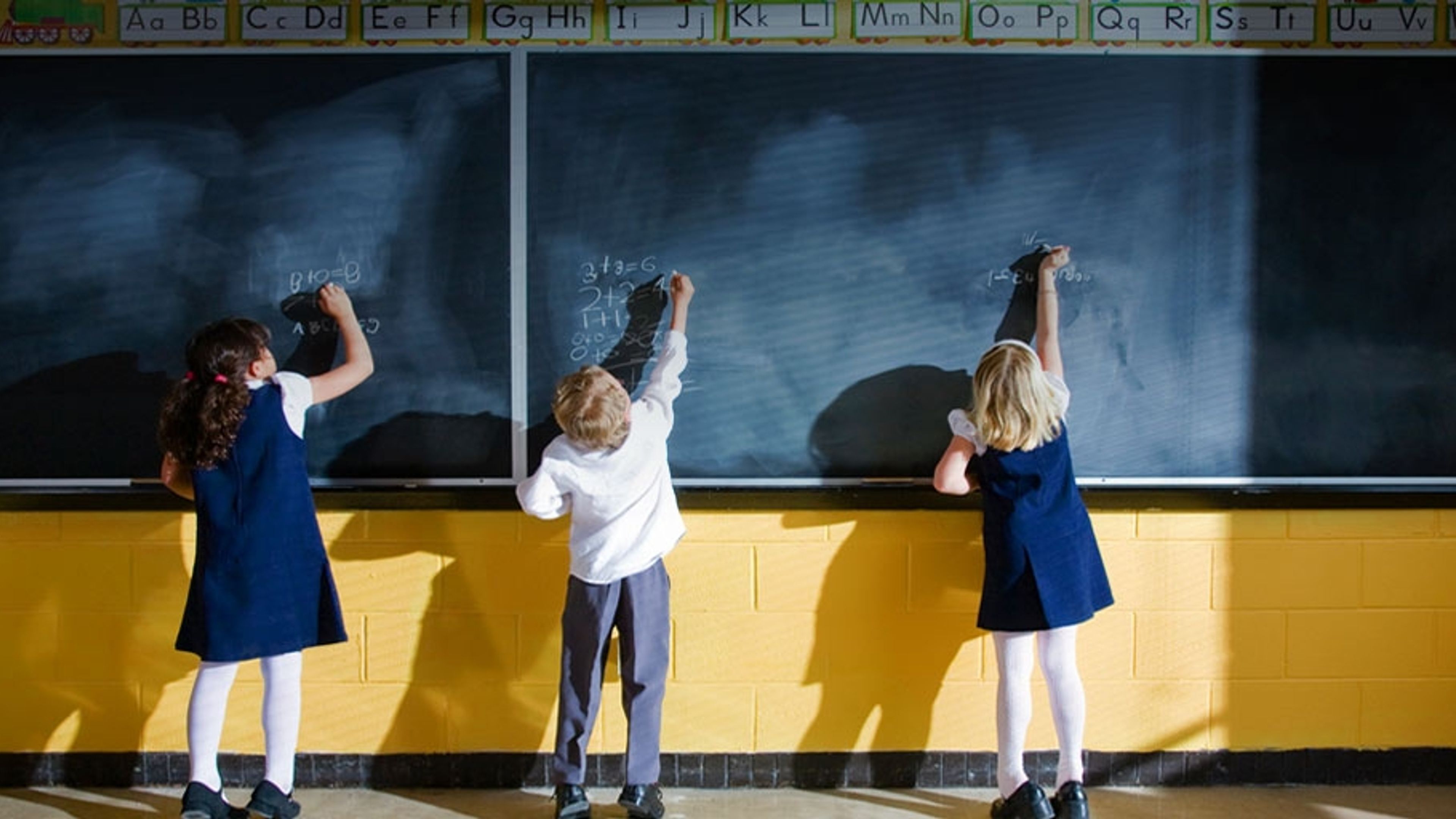 Three students writing on blackboard in classroom - Bing Gallery